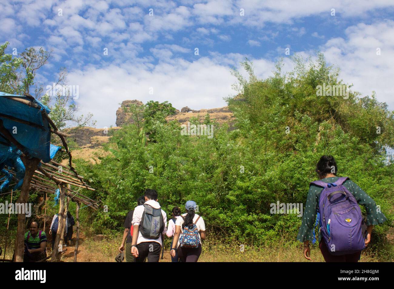 Group of hikers climbing a desolate brown mountain. Irshalgad fort ...