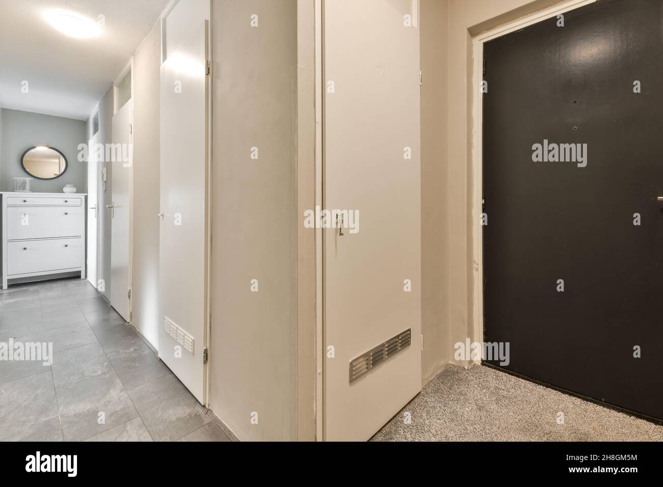 Long stylish corridor with a black entrance door Stock Photo - Alamy