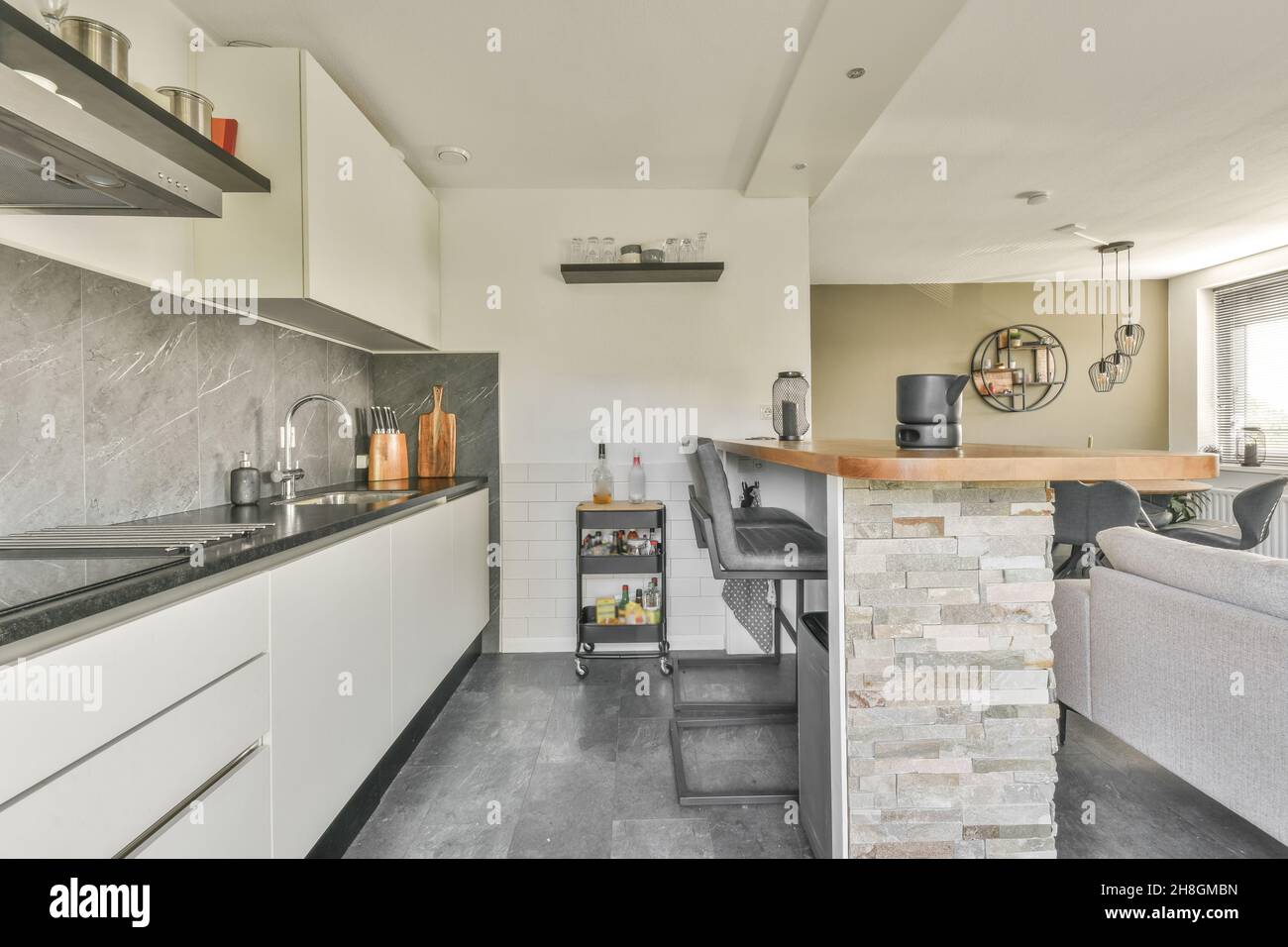 Luxury kitchen in shades of gray with a worktop and high-legged chairs ...