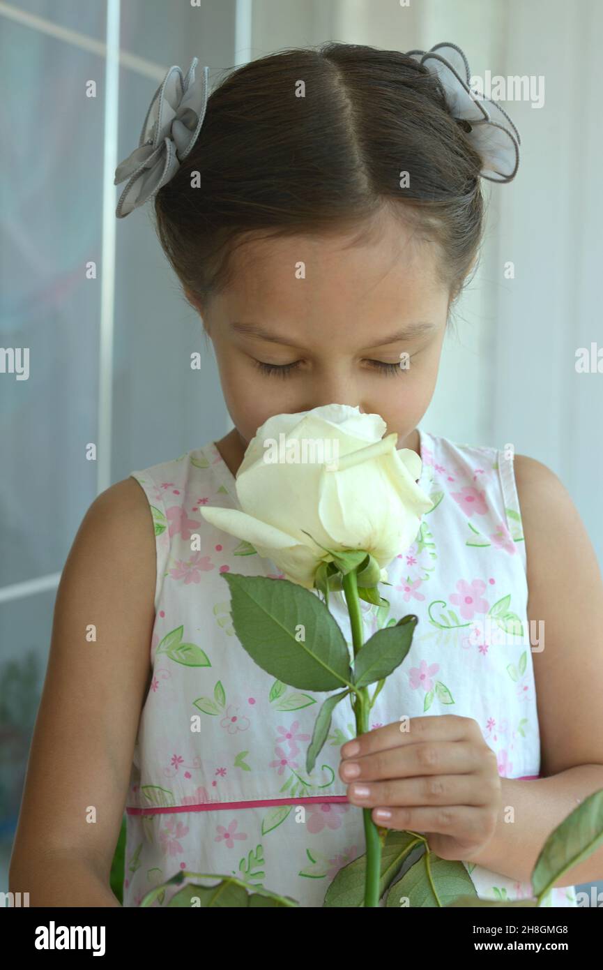 Cute little girl at home holding rose Stock Photo - Alamy