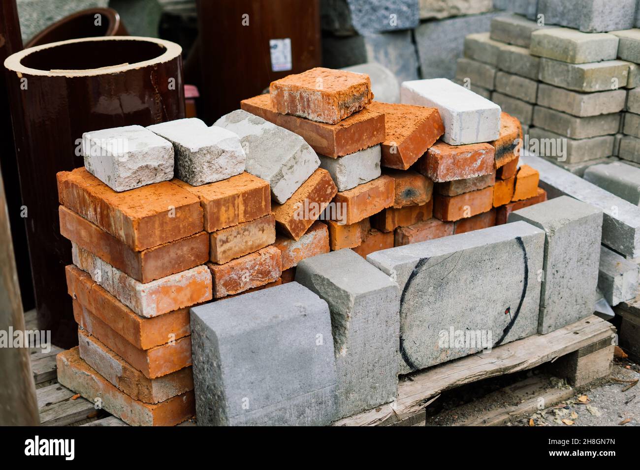 Large sectional sewer pipes, bricks, paves in a warehouse construction ...
