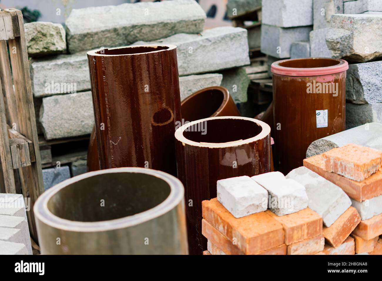 Large sectional sewer pipes, bricks, paves in a warehouse construction ...