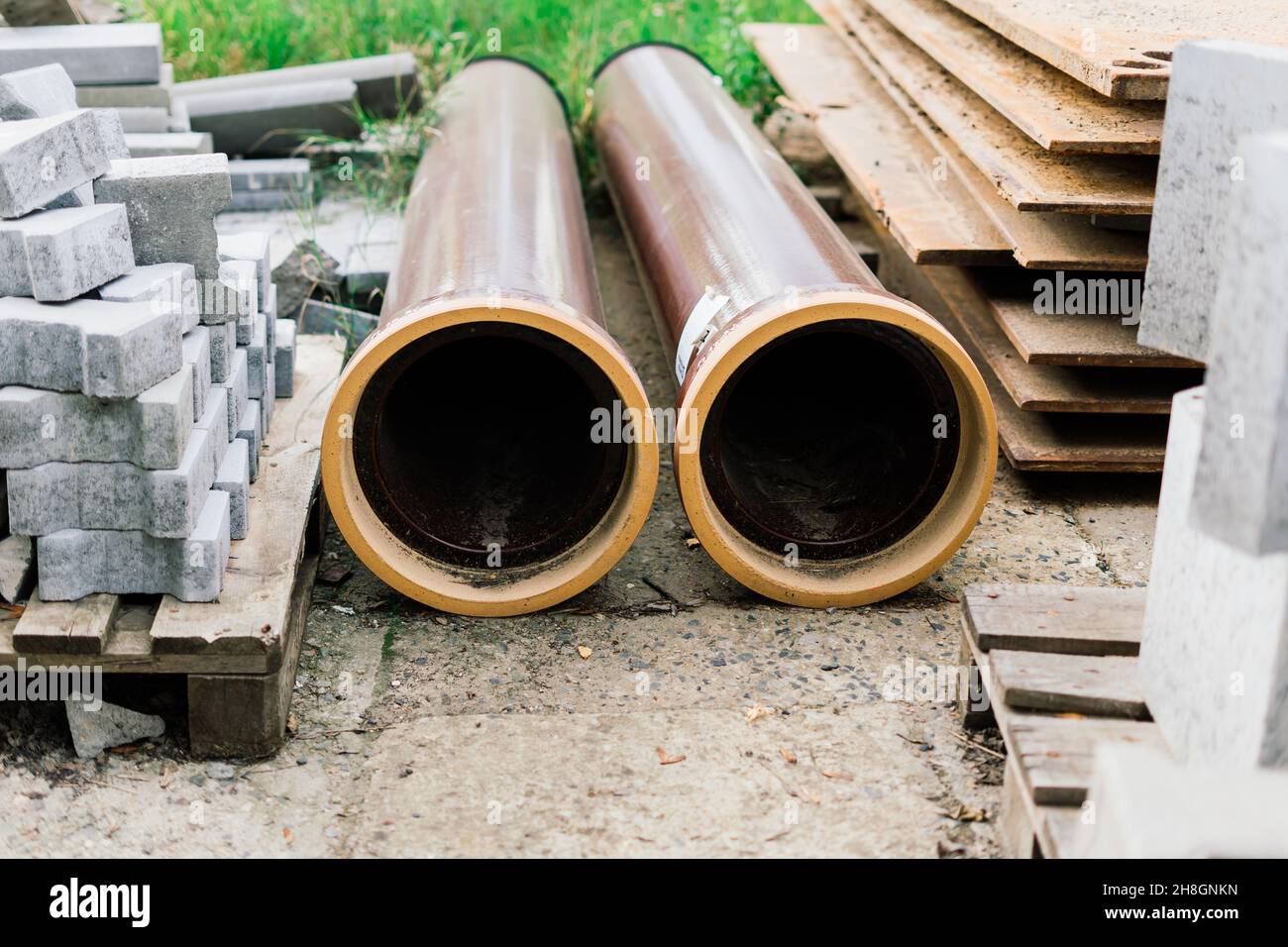 Large sectional sewer pipes, bricks, paves in a warehouse construction ...