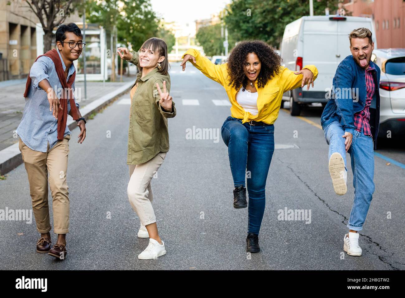 Mixed race group of friends having fun walking in a foolish way by ...