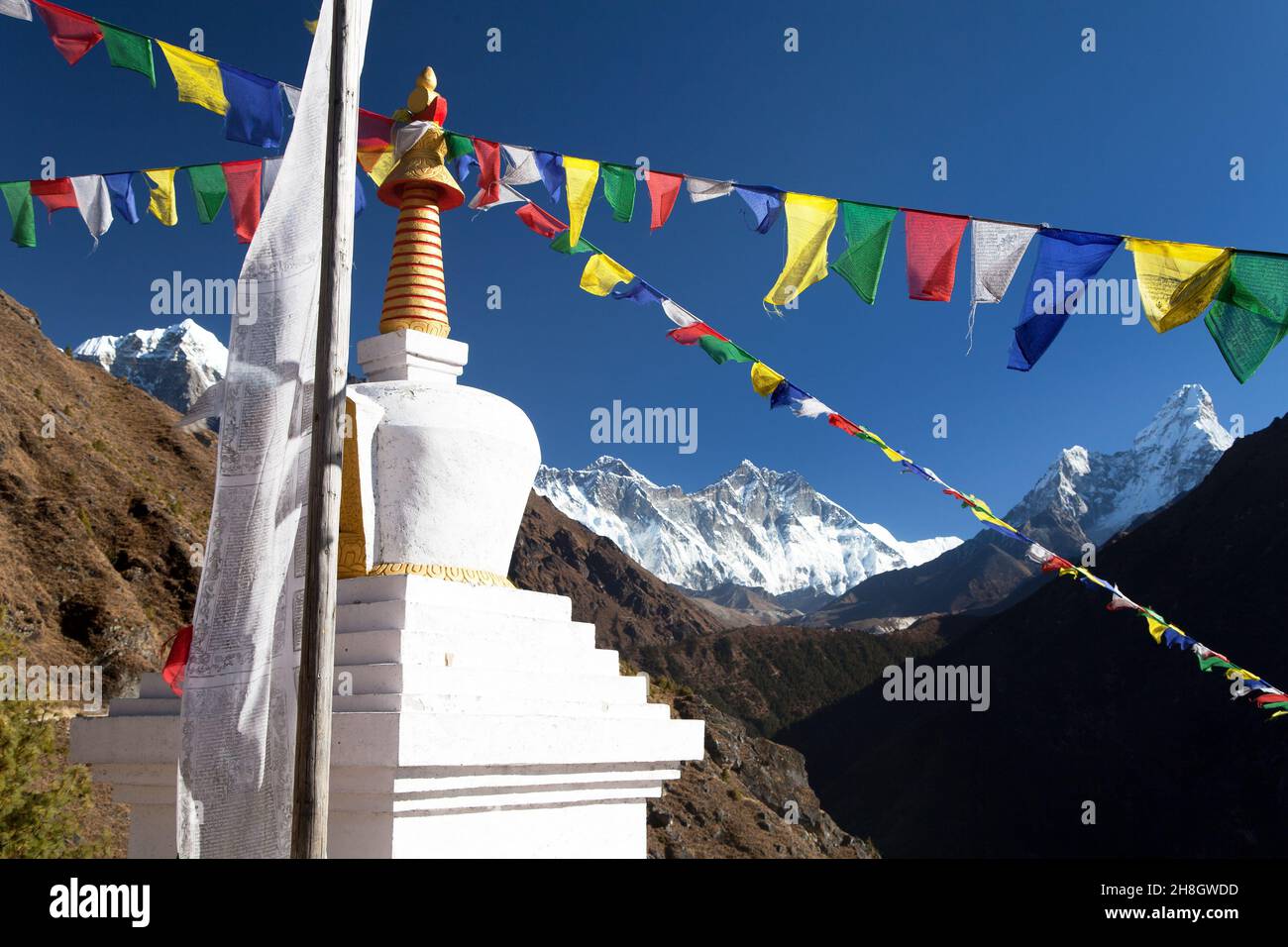 White stupa and prayer flags near Namche Bazar, mount Everest, Lhotse ...