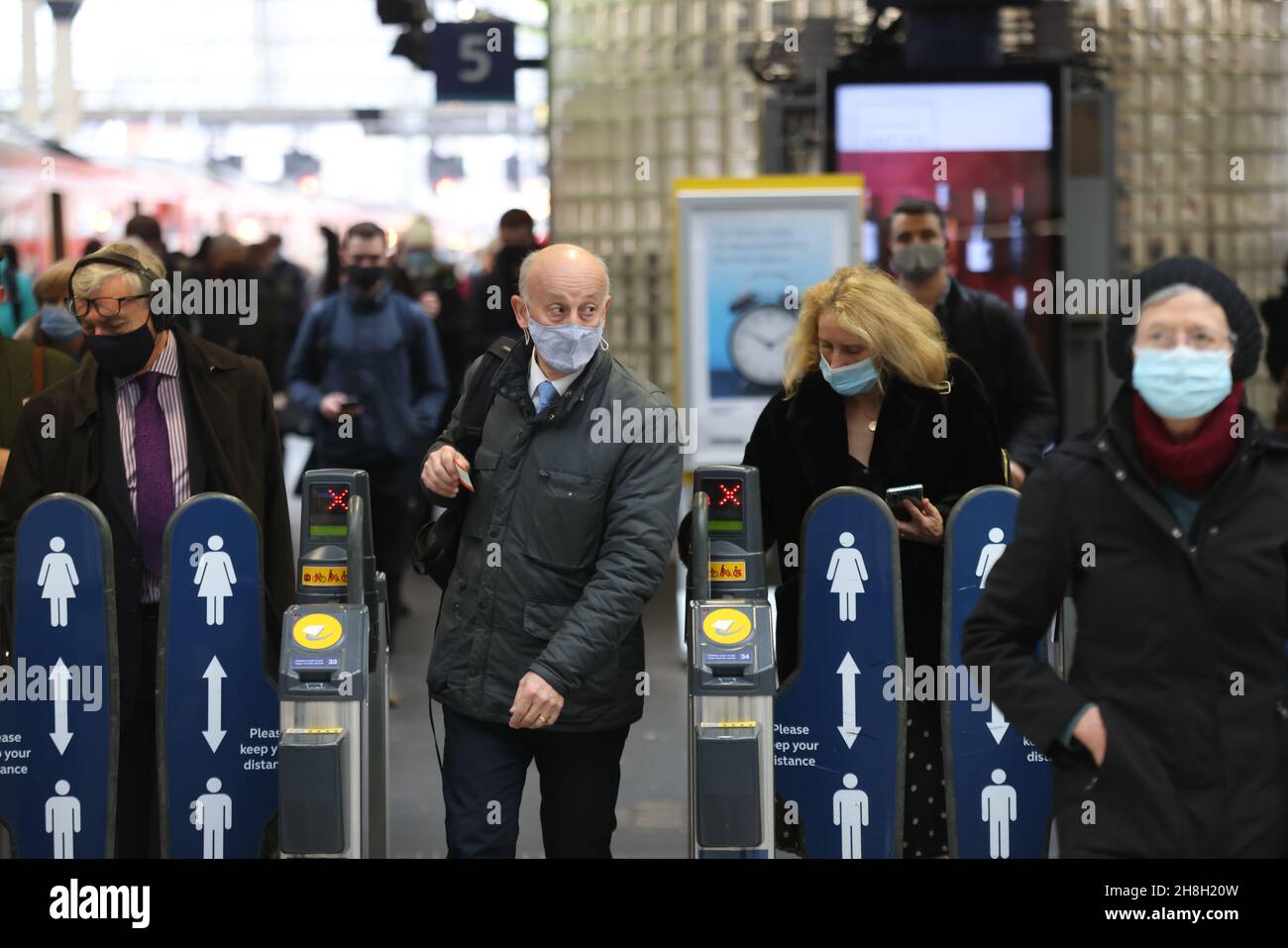 Passengers wearing masks travelling via Waterloo station in London, as ...