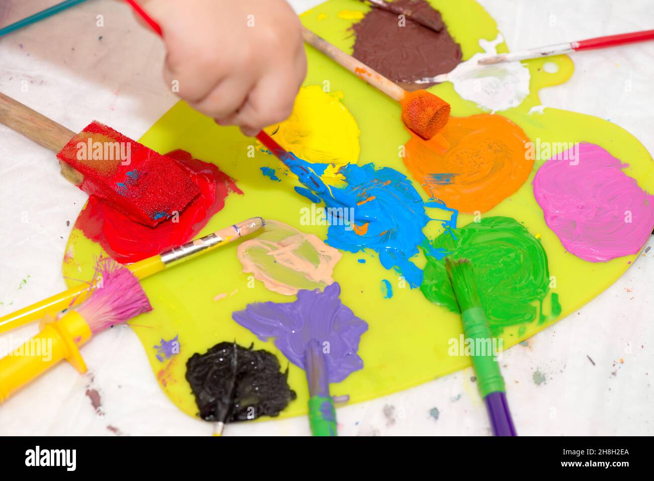 Hand of a child mixing colors on an easel Stock Photo - Alamy