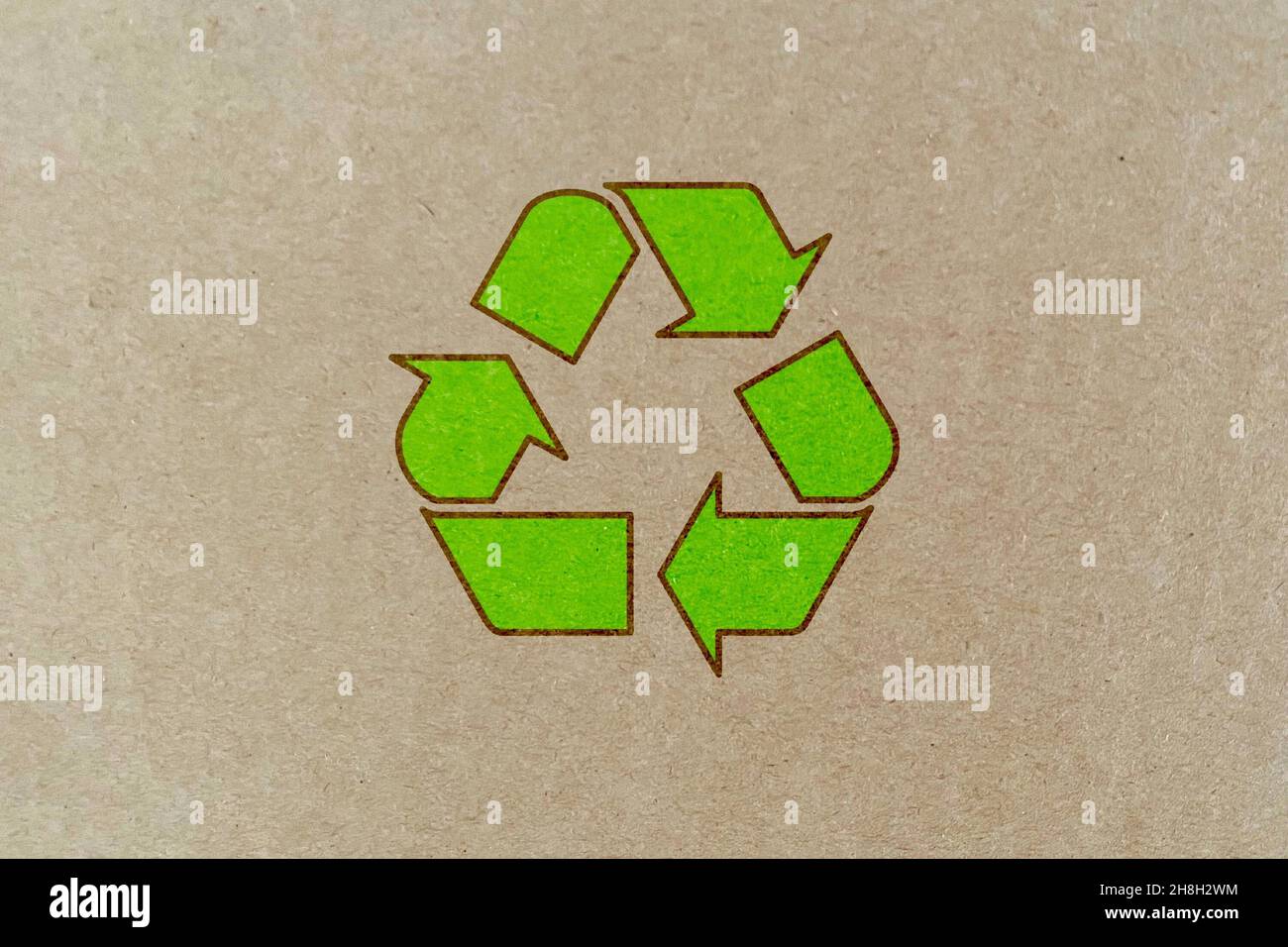 Green recycling arrow icon isolated on cardboard packaging paper background Stock Photo - Alamy