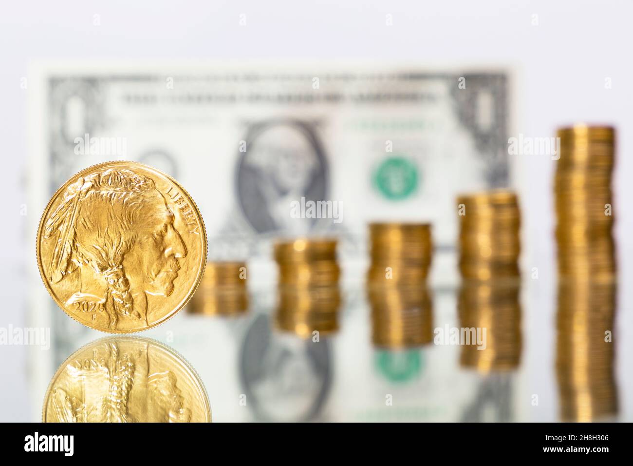 Gold coin with stack of cash and coins Stock Photo - Alamy