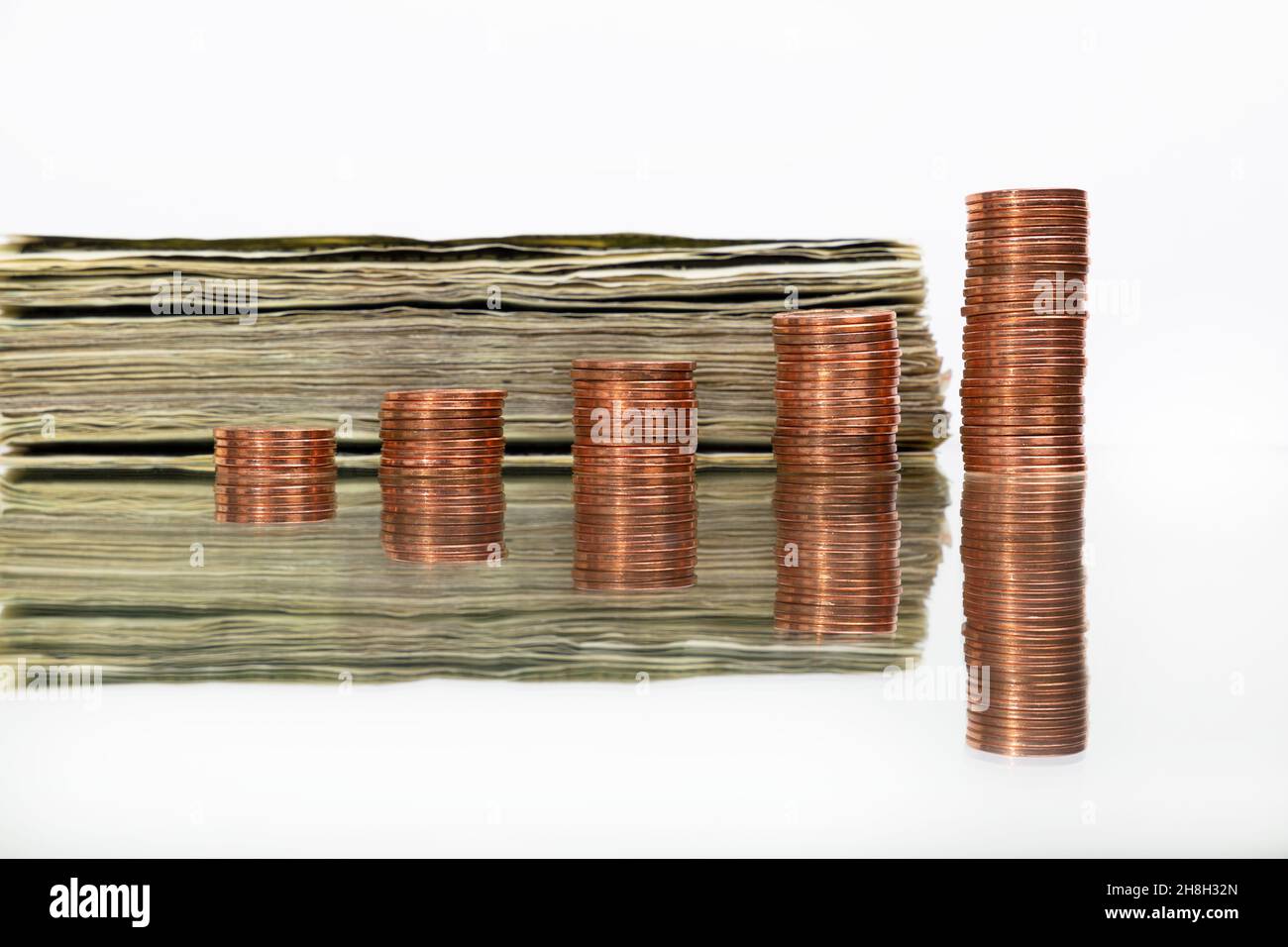 Stack of cash and copper on white table Stock Photo - Alamy