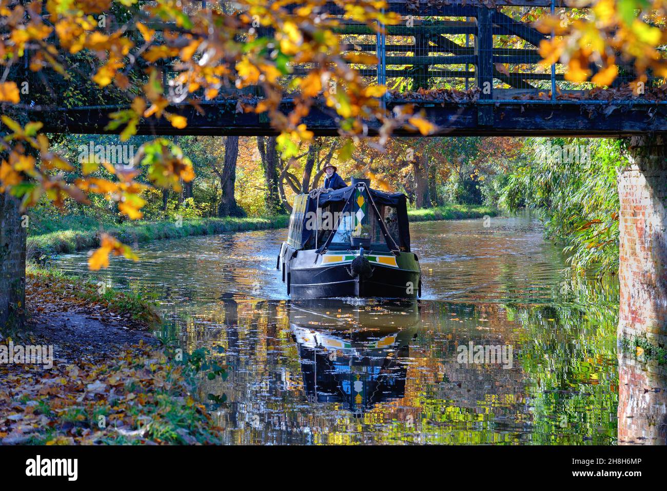 A narrow boat cruising through the colourful autumnal countryside on ...