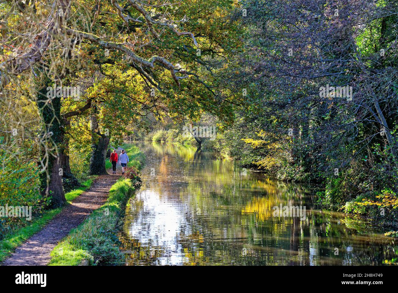 A couple walking on the towpath by the River Wey navigation canal on a ...