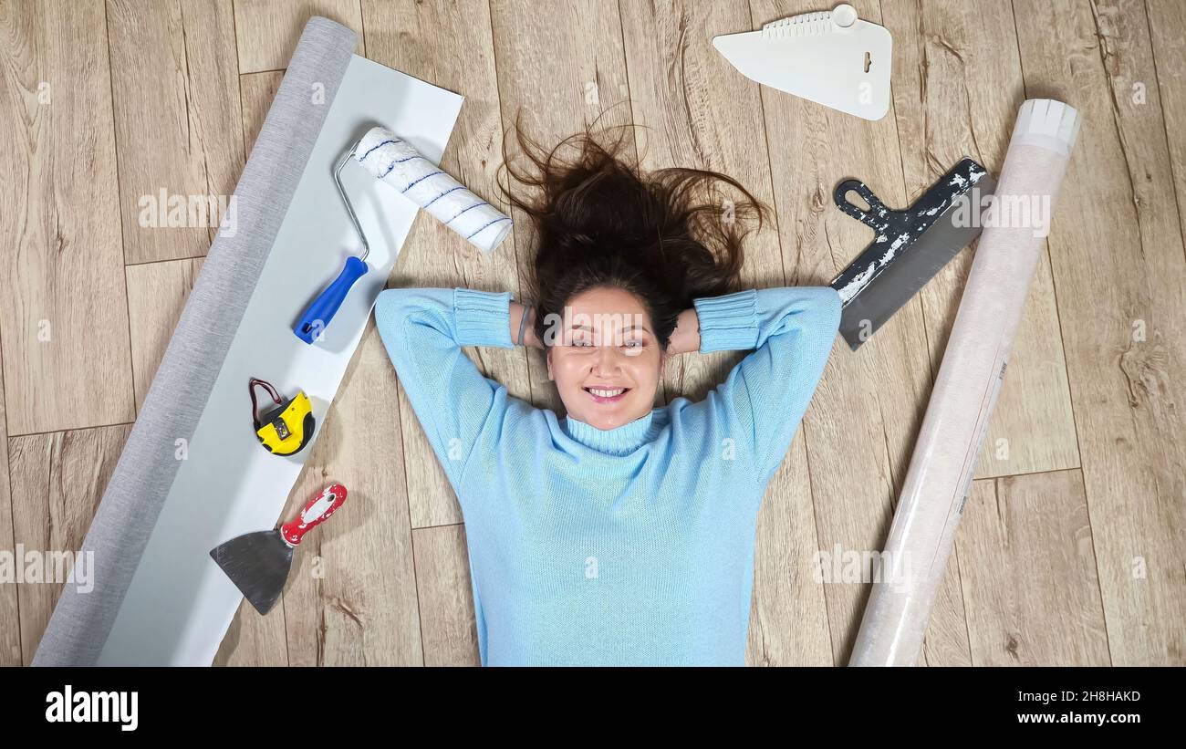 Woman lies on floor among scattered building materials Stock Photo - Alamy