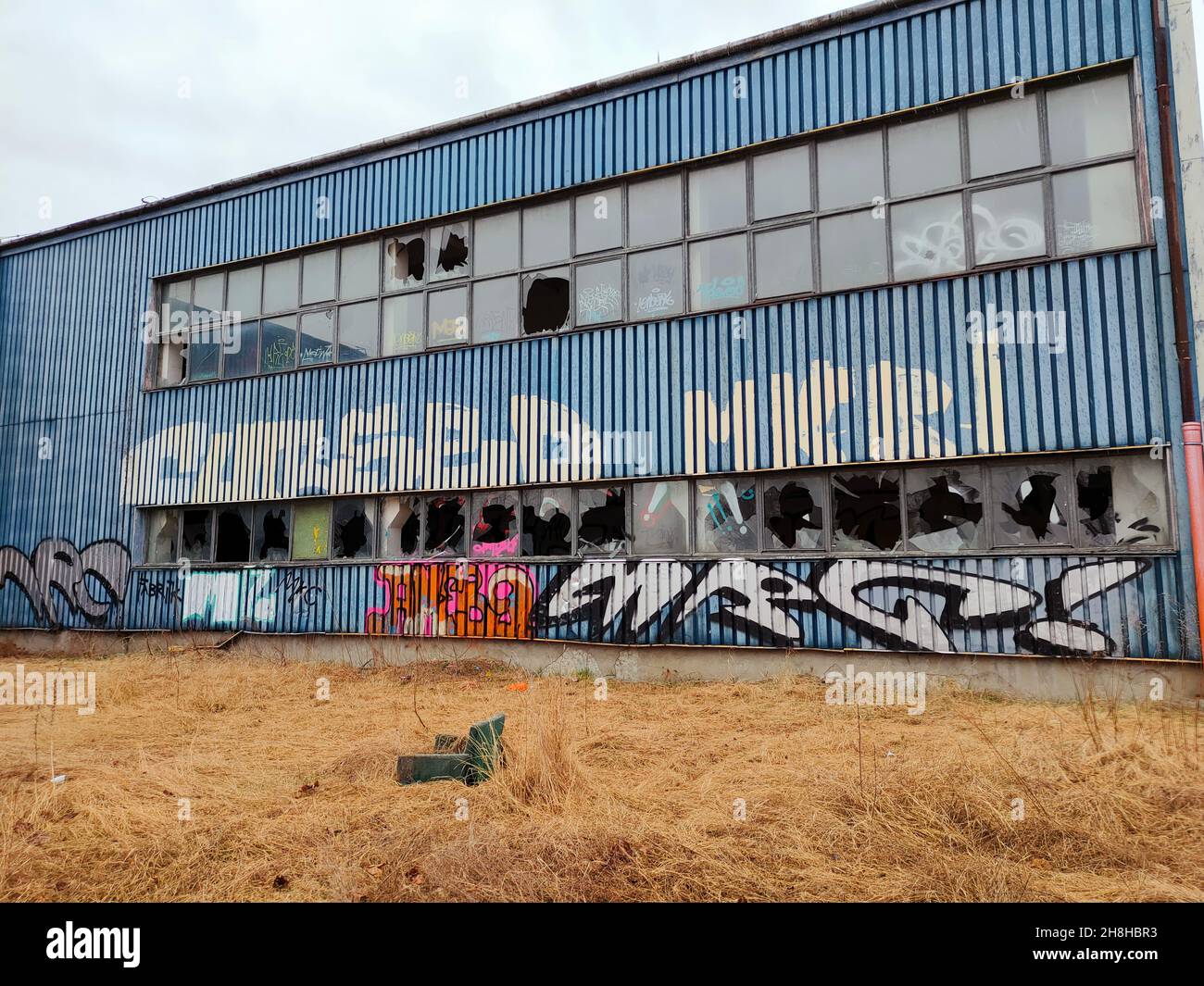 Large warehouse with glass windows being shot with a shotgun. Abandoned ...