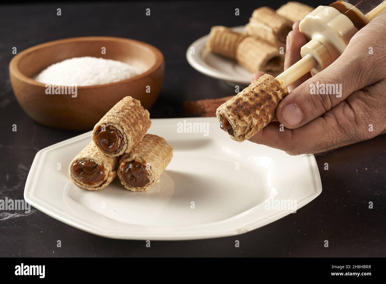 Hand stuffing cubanitos with dulce de leche Stock Photo - Alamy