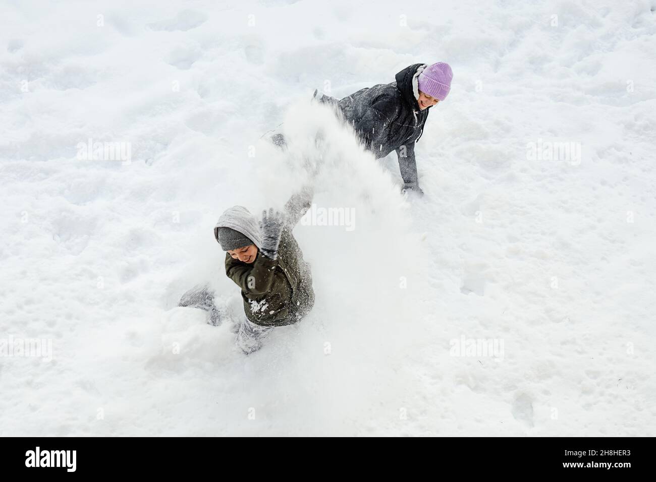 Boy and girl, teenagers, brother, Sister indulge, roll around in snow ...