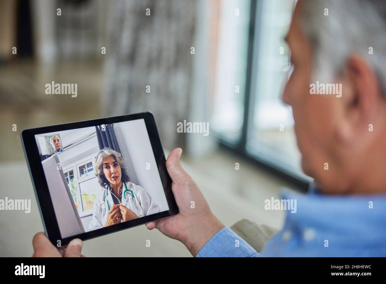 Man Having Remote Consultation With Doctor At Home Using Digital Tablet ...