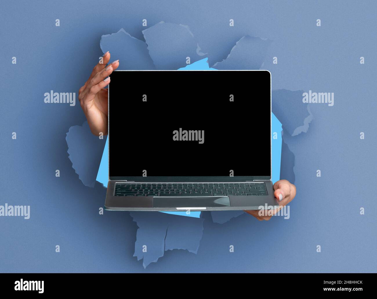 Person showing black empty laptop screen breaking through paper Stock ...