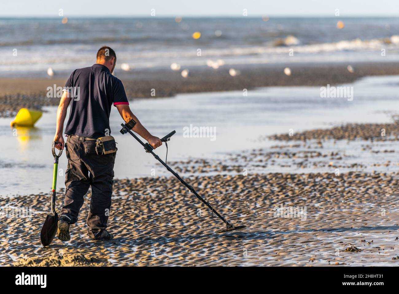 France, Somme, Quend-Plage, A man with a metal detector on the beach ...