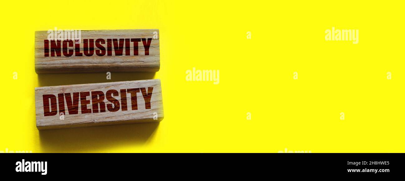 Inclusivity diversity words on wooden block on the yellow background ...