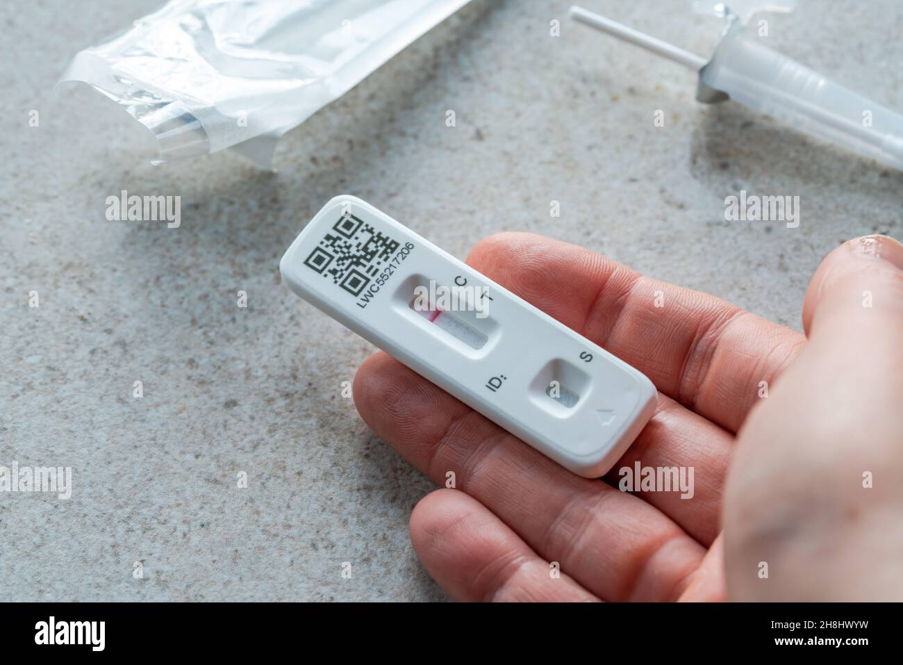 Female hand holds rapid lateral flow test device which shows negative ...