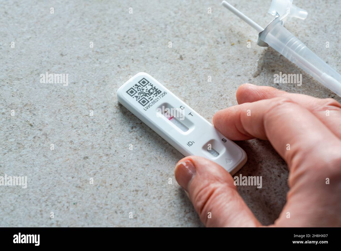 Female hand holds rapid lateral flow test device which shows negative ...