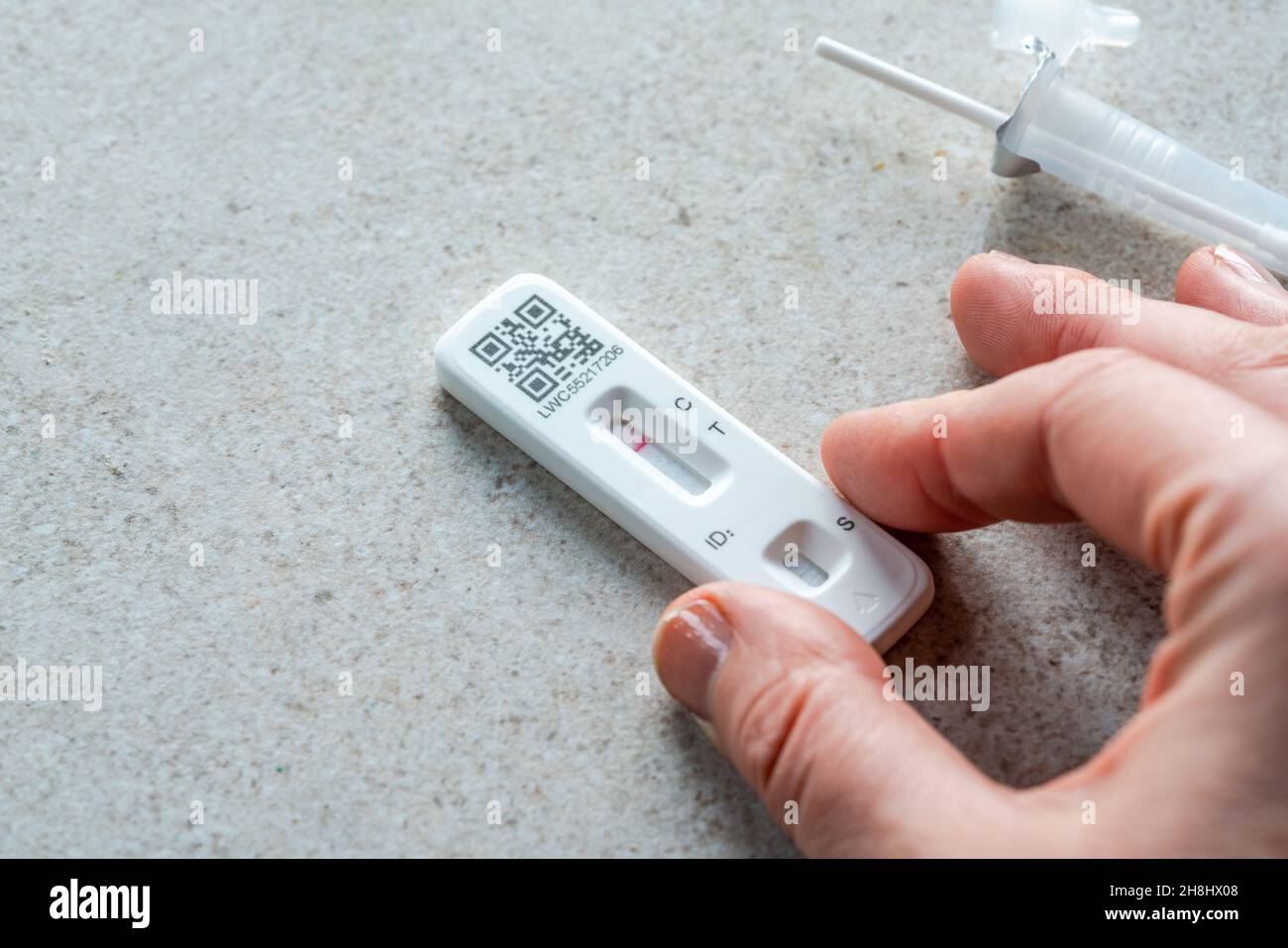 Female hand holds rapid lateral flow test device which shows negative ...