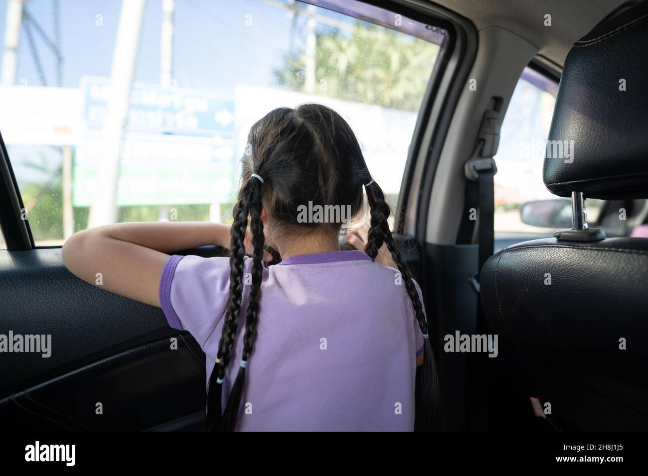 Backside of Little Asian 5 years old girl, is looking to the outside ...