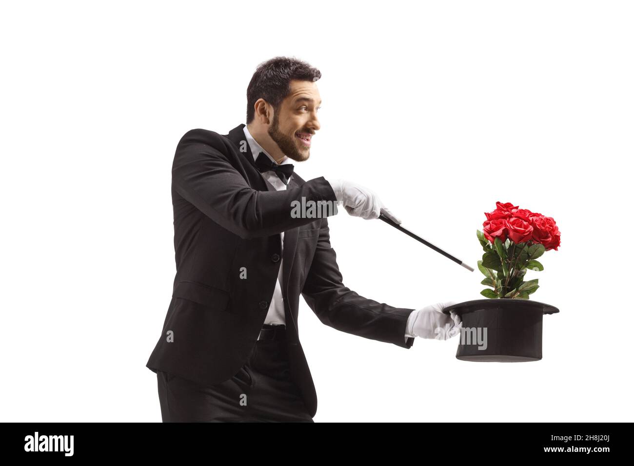 Profile shot of a magician performing a trick with hat and roses ...