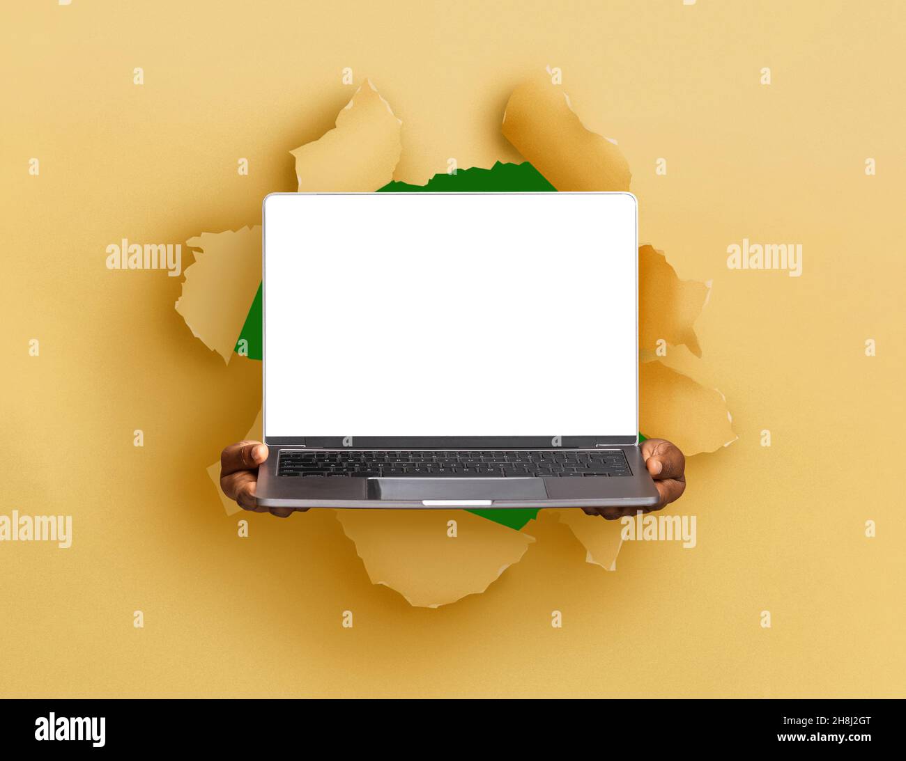 Person showing black empty laptop screen breaking through paper Stock ...