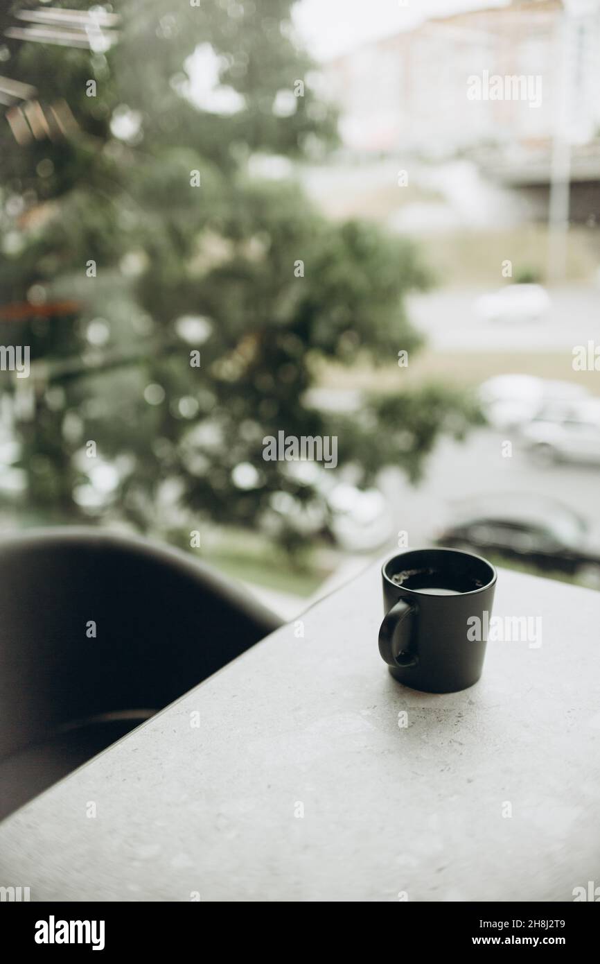 Single coffee cup on table with an urban background Stock Photo - Alamy
