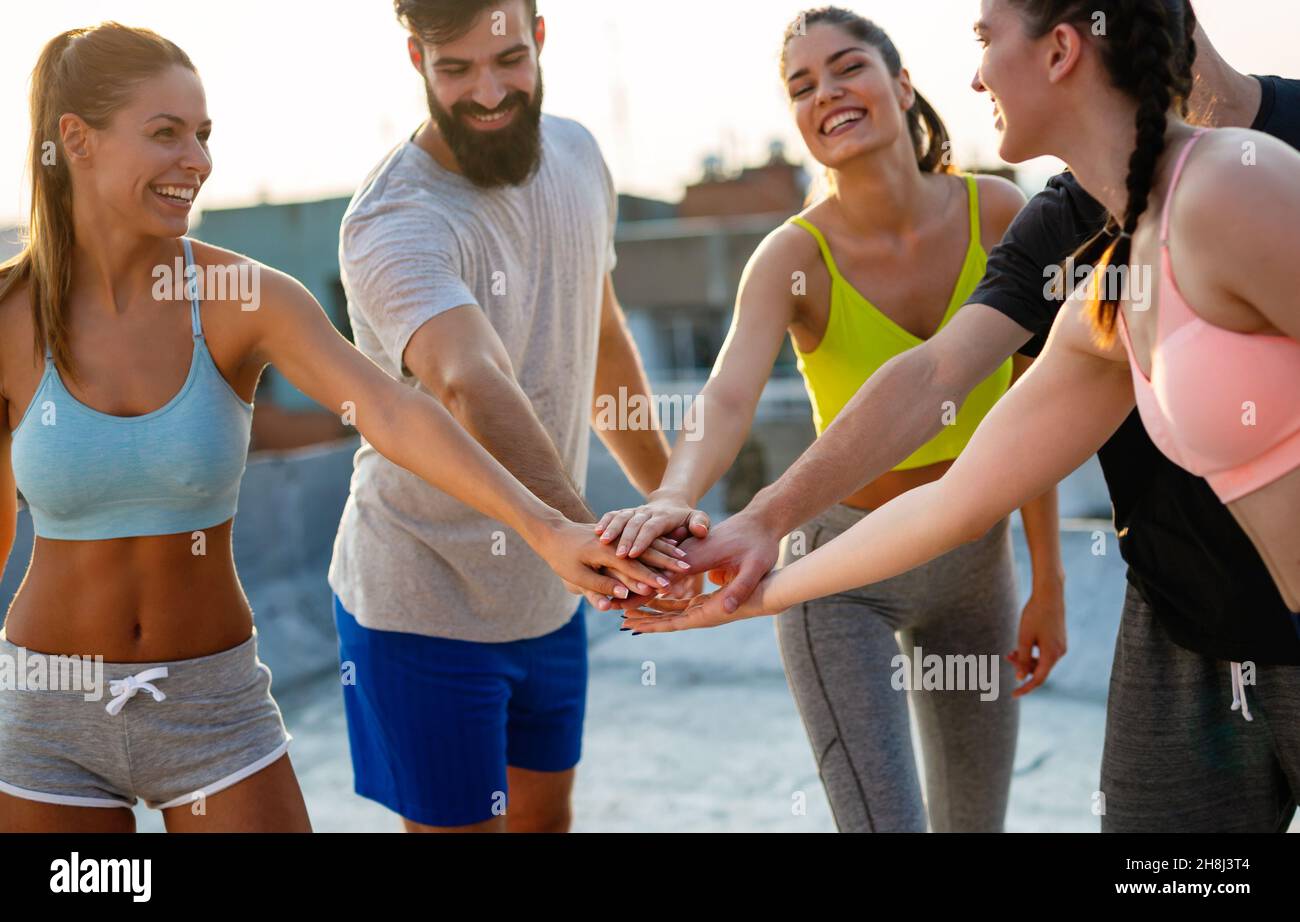 Group of happy fitness people training together outdoors, living active ...