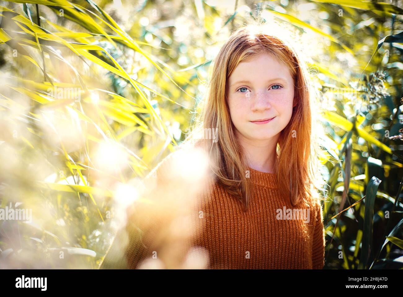 Tween girl with red hair outdoors tall grass Stock Photo - Alamy