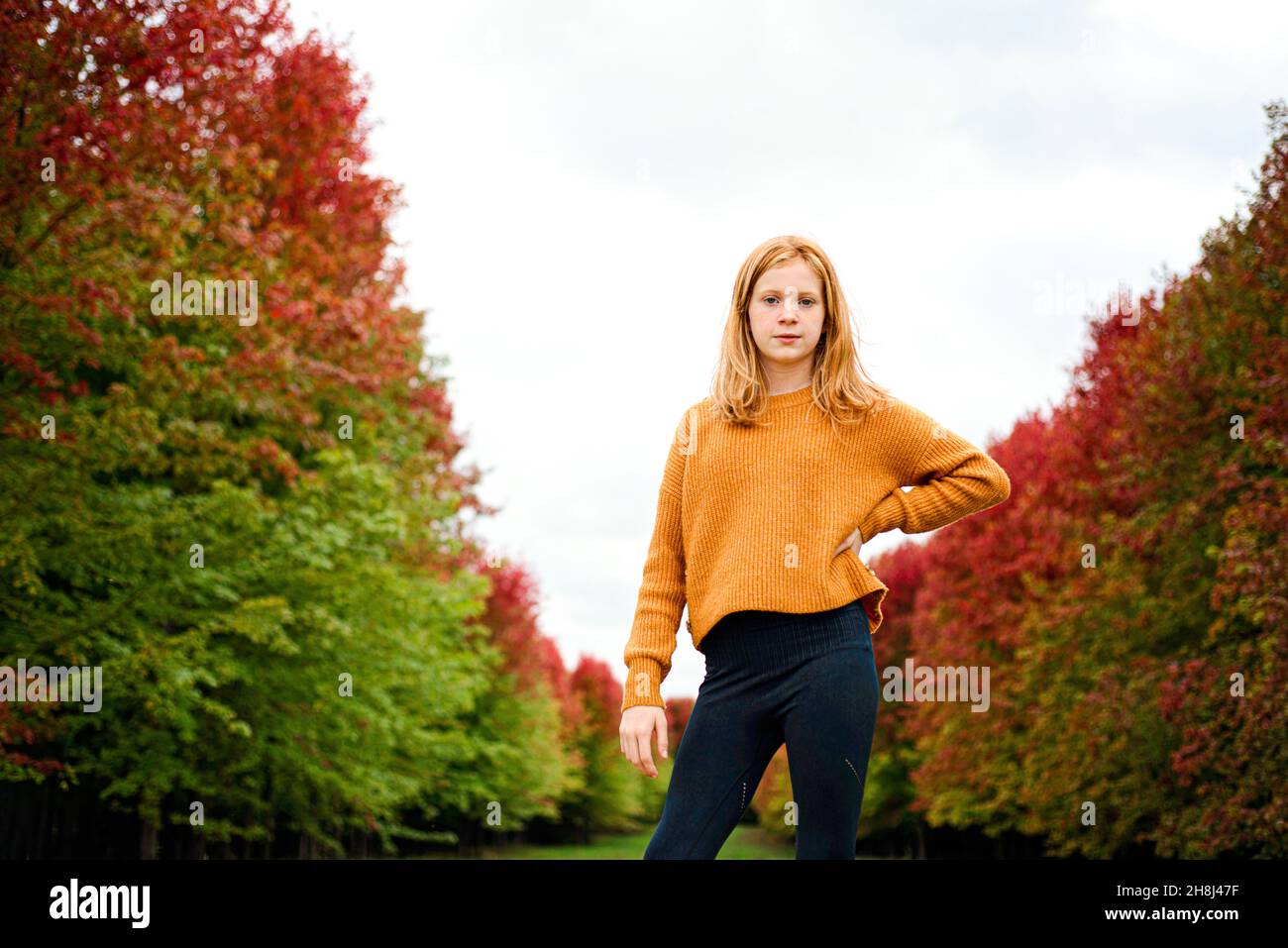 Happy tween girl surrounded by fall color trees Stock Photo - Alamy