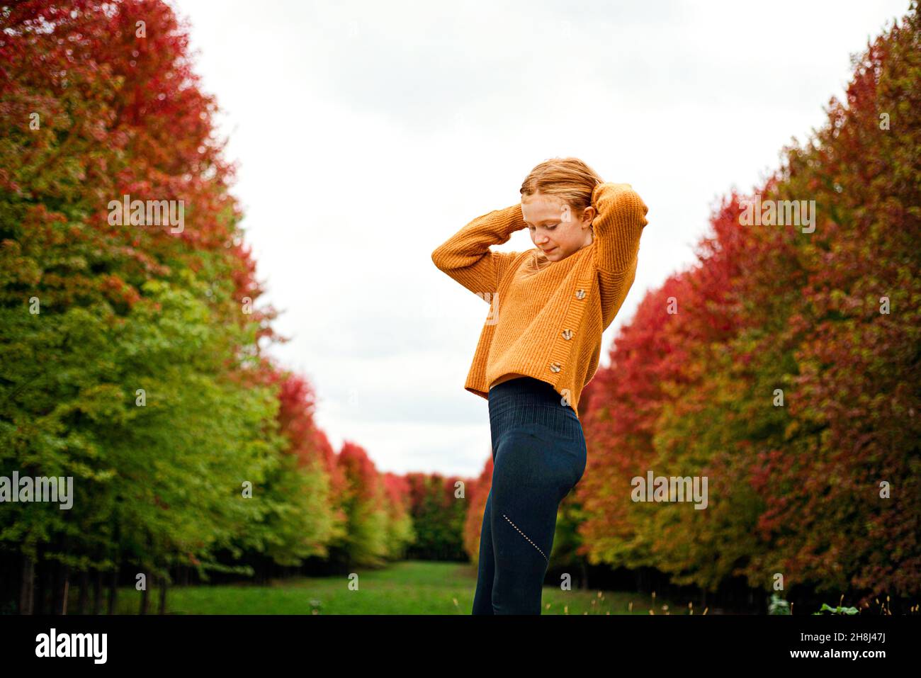Happy tween girl surrounded by fall color trees Stock Photo - Alamy