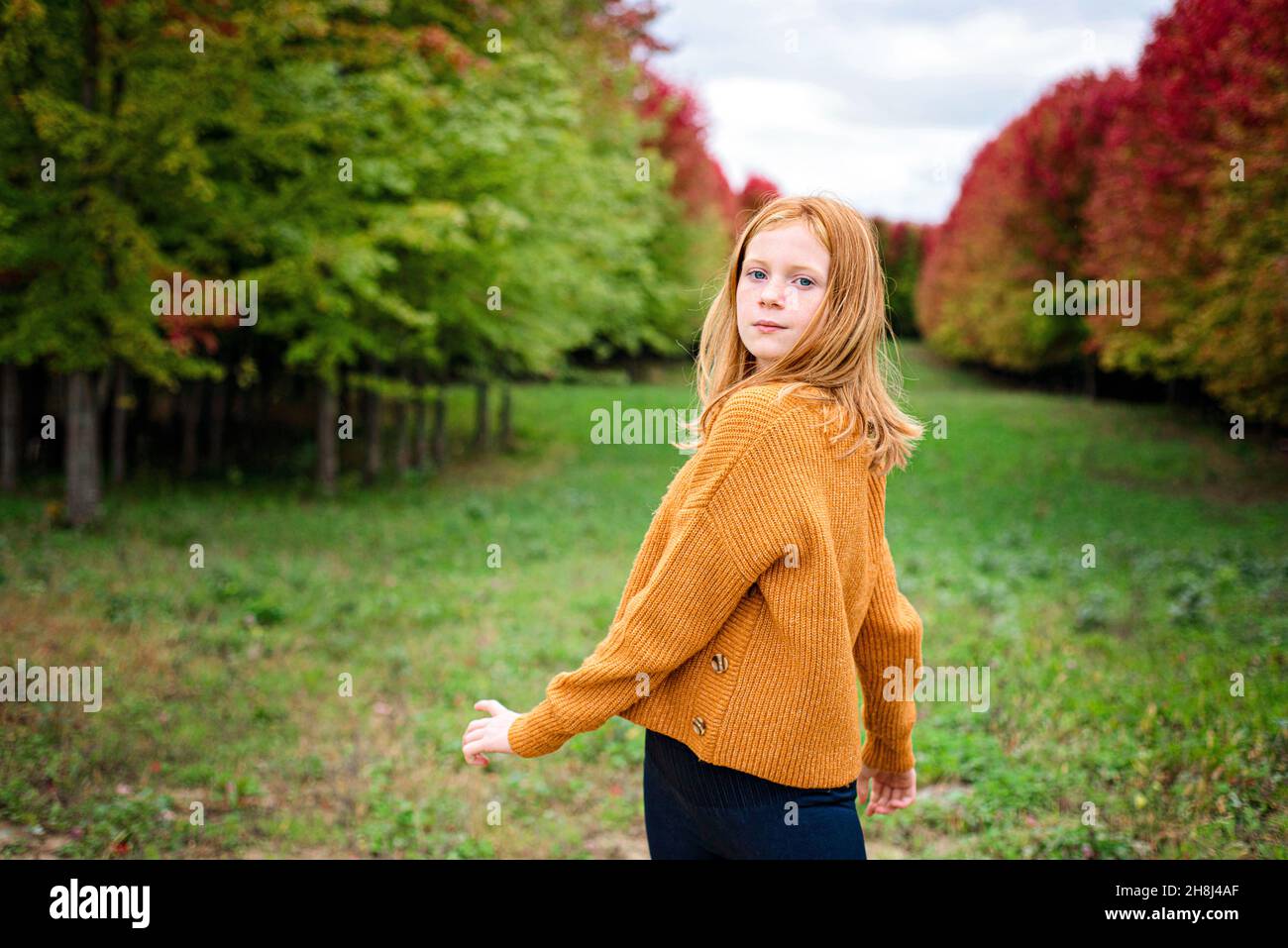 Happy tween girl surrounded by fall color trees Stock Photo - Alamy