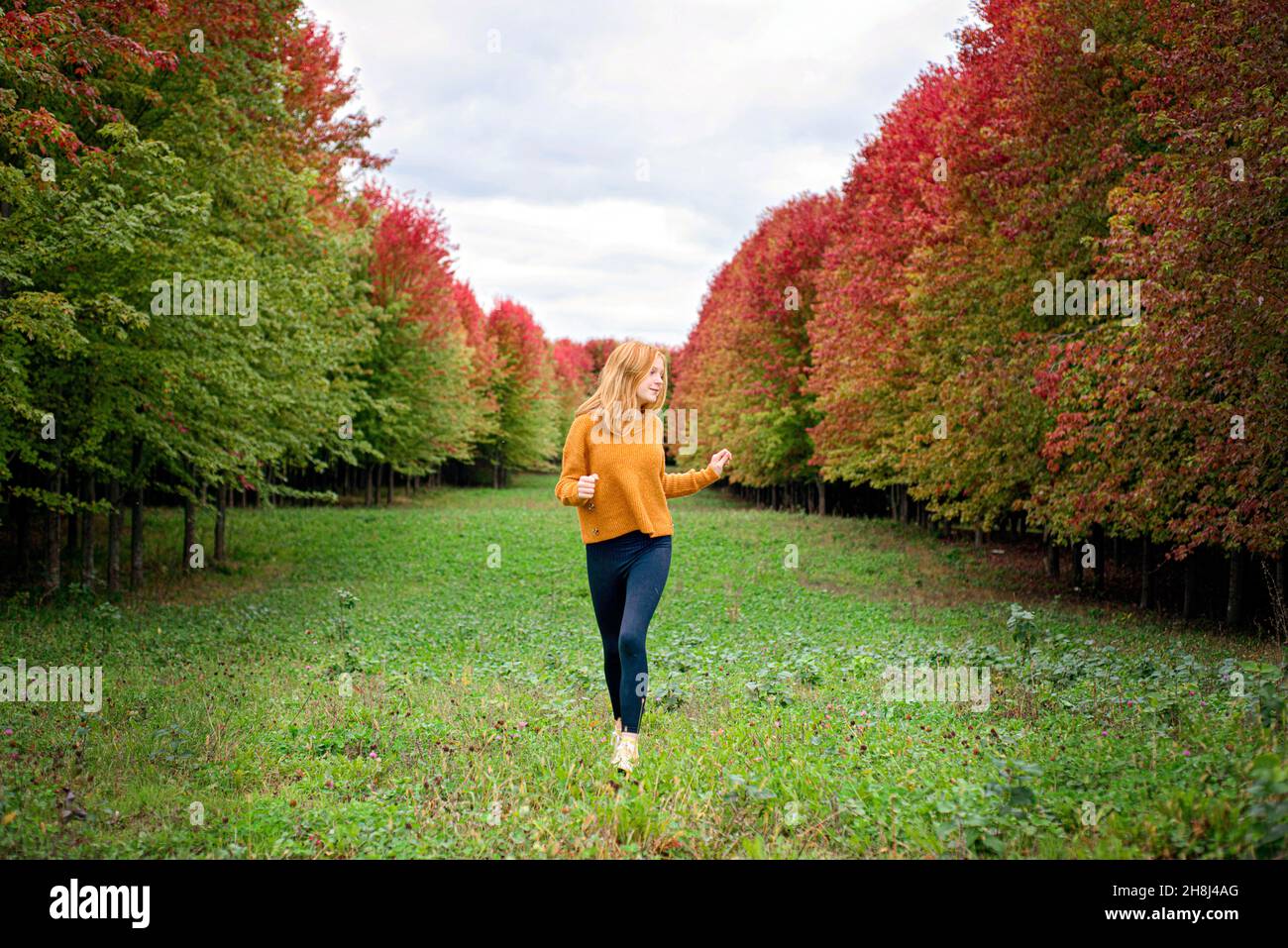 Happy tween girl surrounded by fall color trees Stock Photo - Alamy