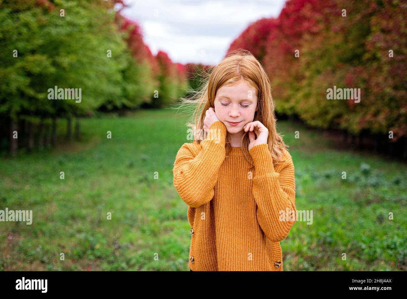 Happy tween girl surrounded by fall color trees Stock Photo - Alamy