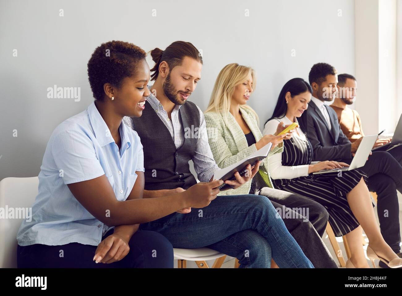 Multiracial people wait in line for interview in office Stock Photo - Alamy