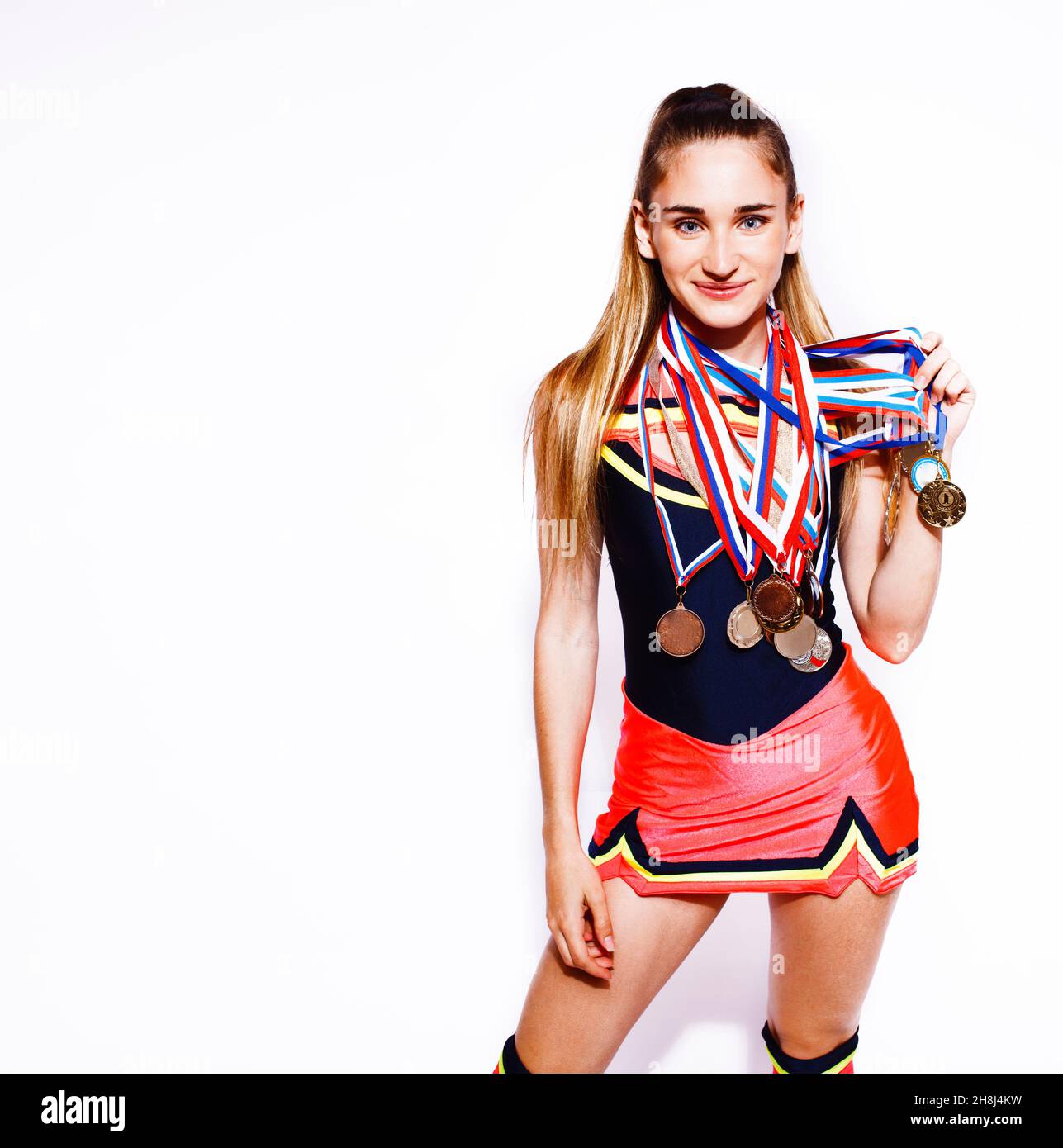 young smiling cheerleader girl with golden cups and price medals ...