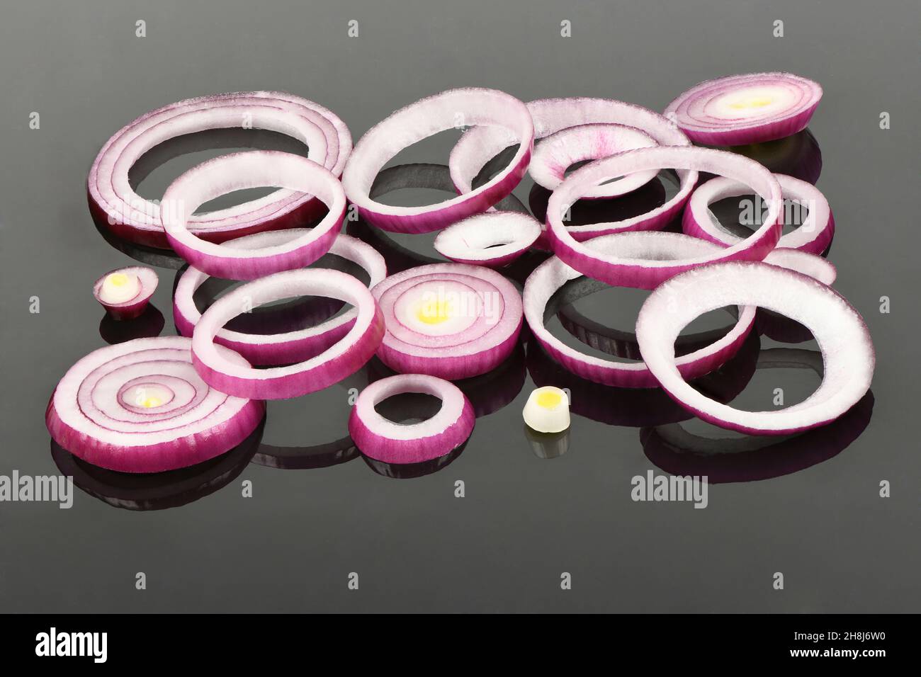 Red onion sliced into rings isolated on an acrylic black background ...