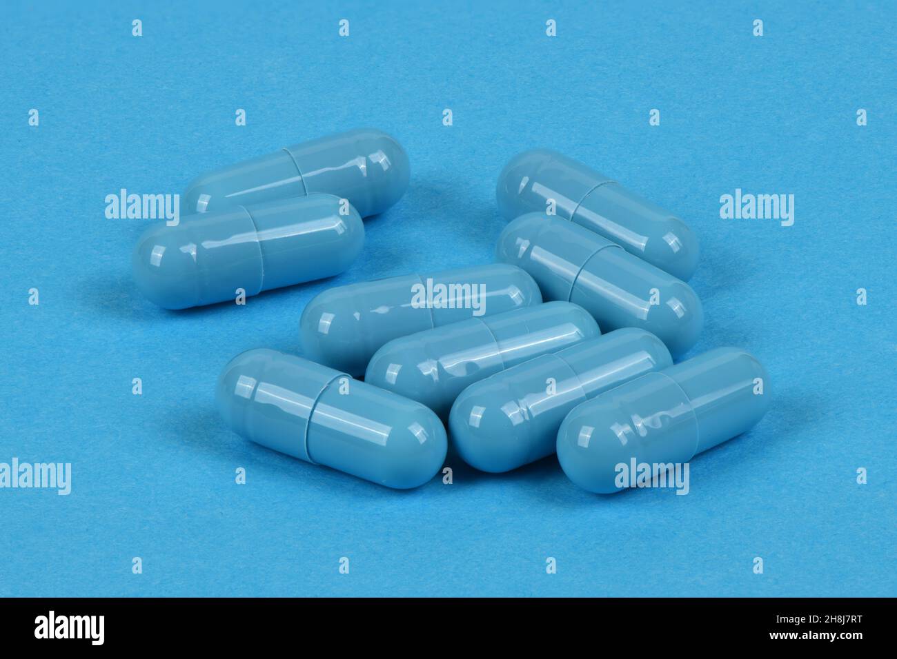 Blue medical capsules pill on blue background. High resolution photo ...