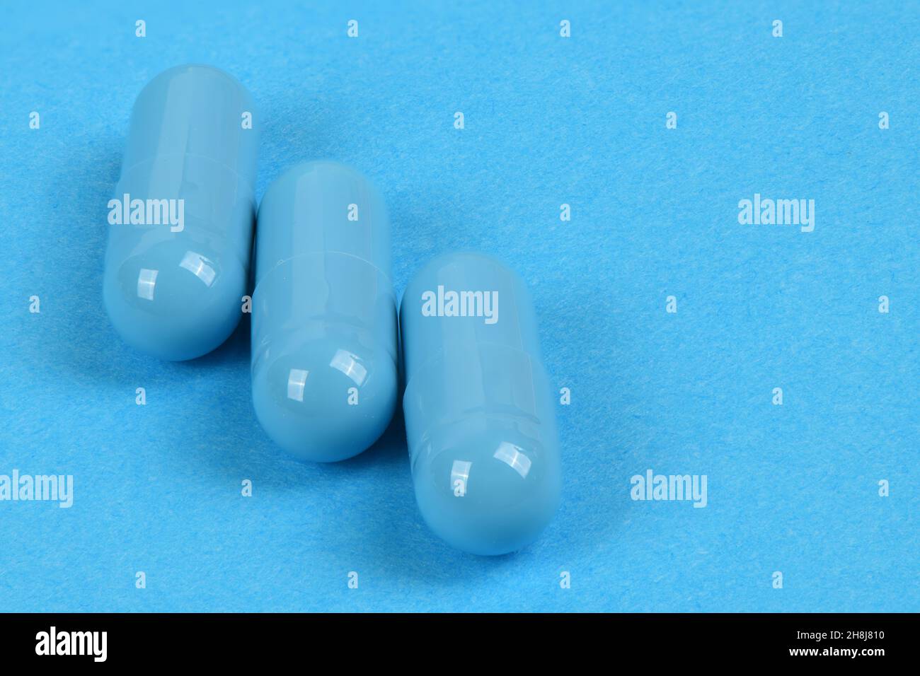 Blue medical capsules pill on blue background. High resolution photo ...