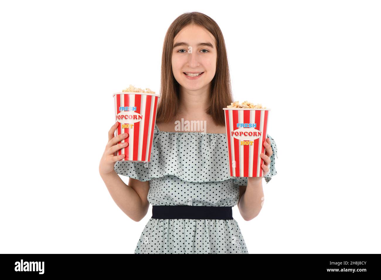 Portrait of a beautiful girl holding bucket of popcorn standing on ...