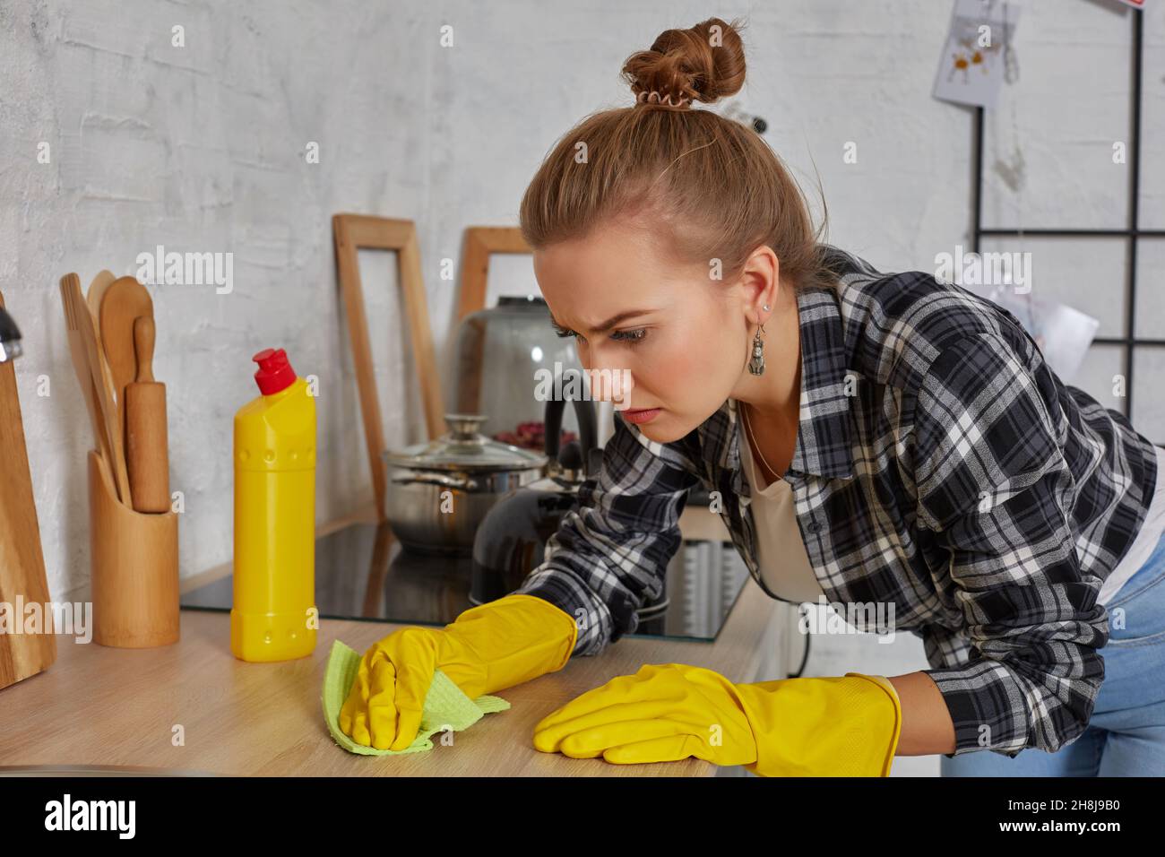 Young woman washing manually, by hand, wearing yellow cleaning rubber ...