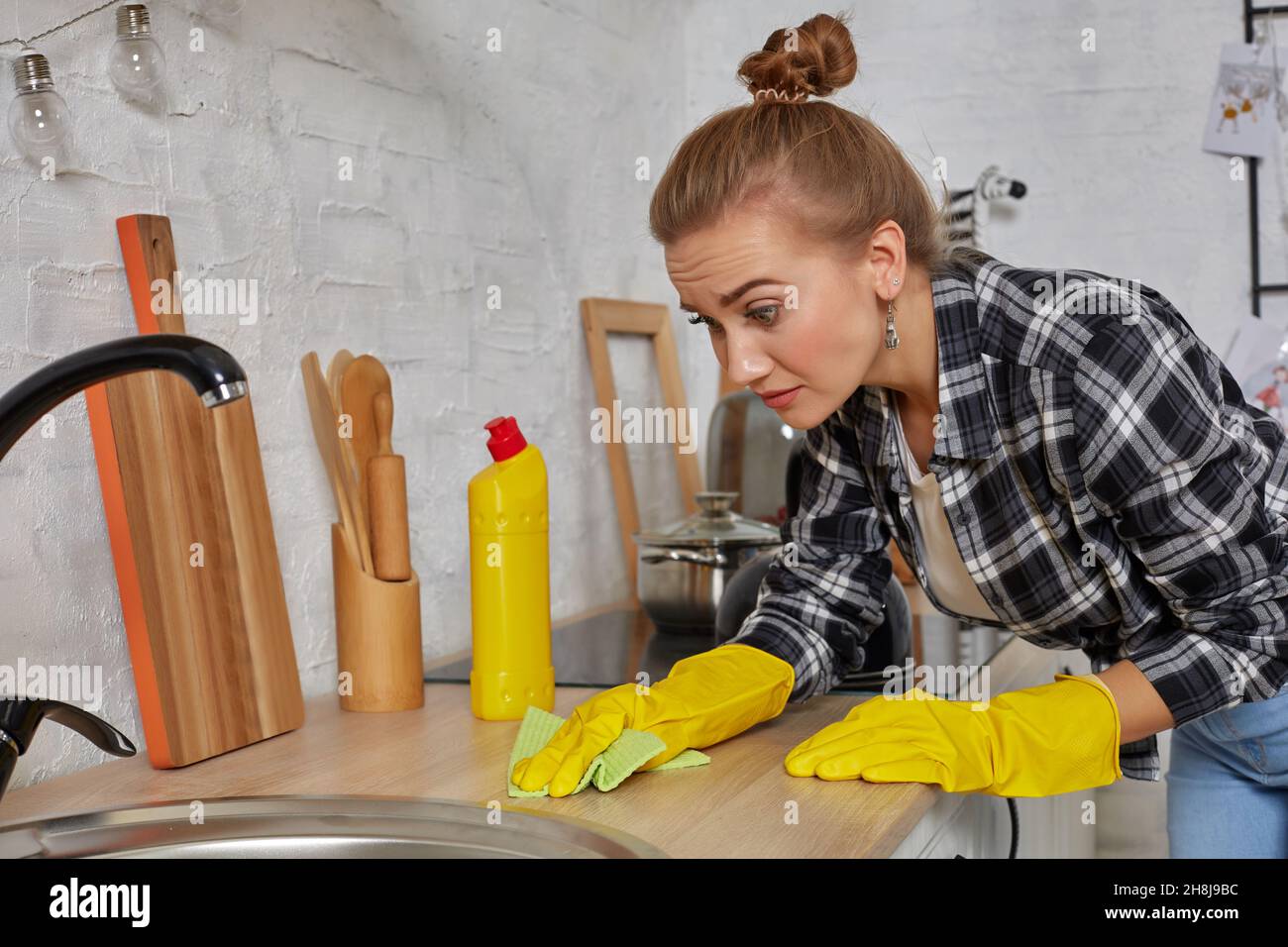 Young woman washing manually, by hand, wearing yellow cleaning rubber ...