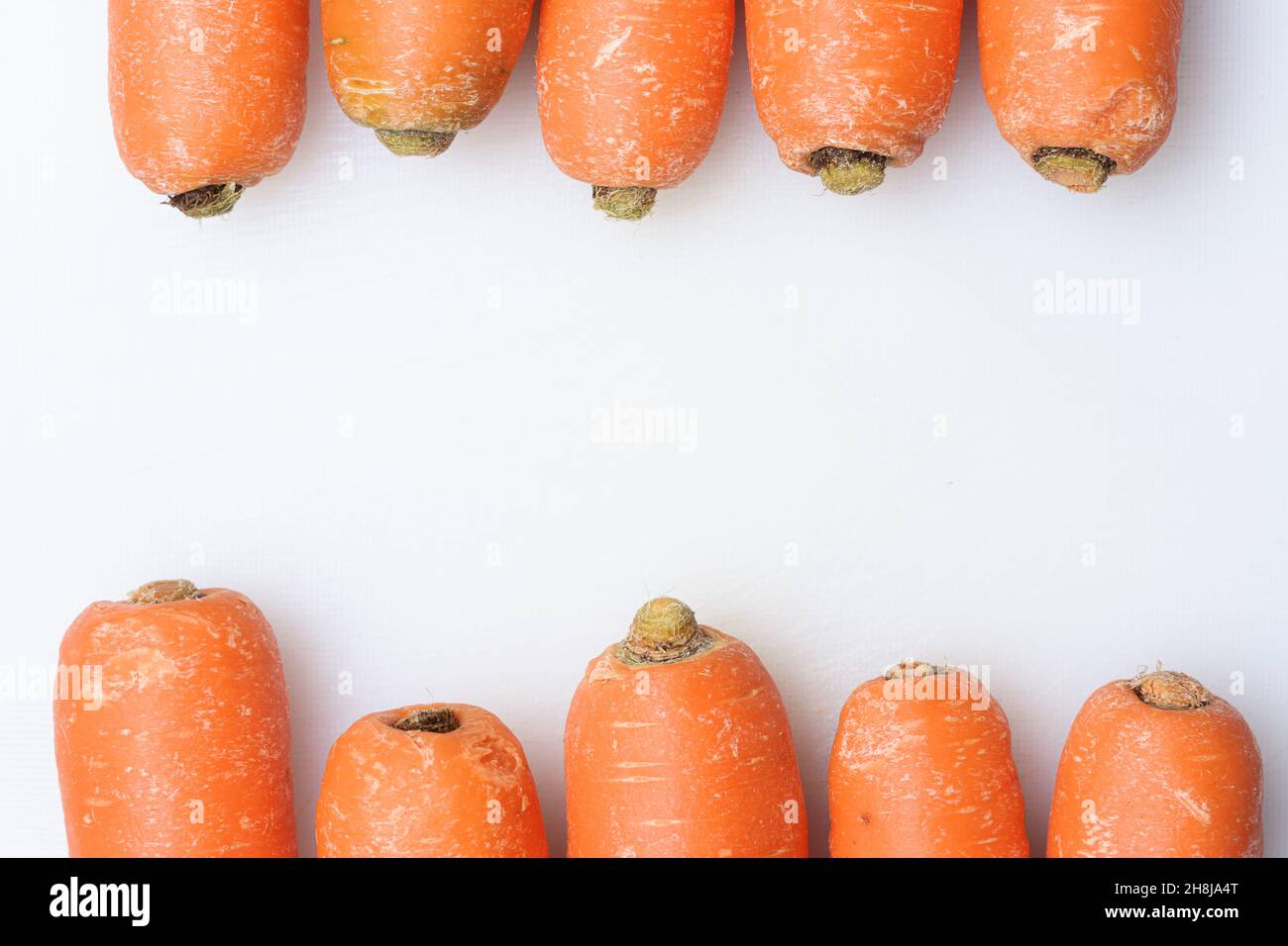 Two lines of carrots on white background. Food concept Stock Photo - Alamy