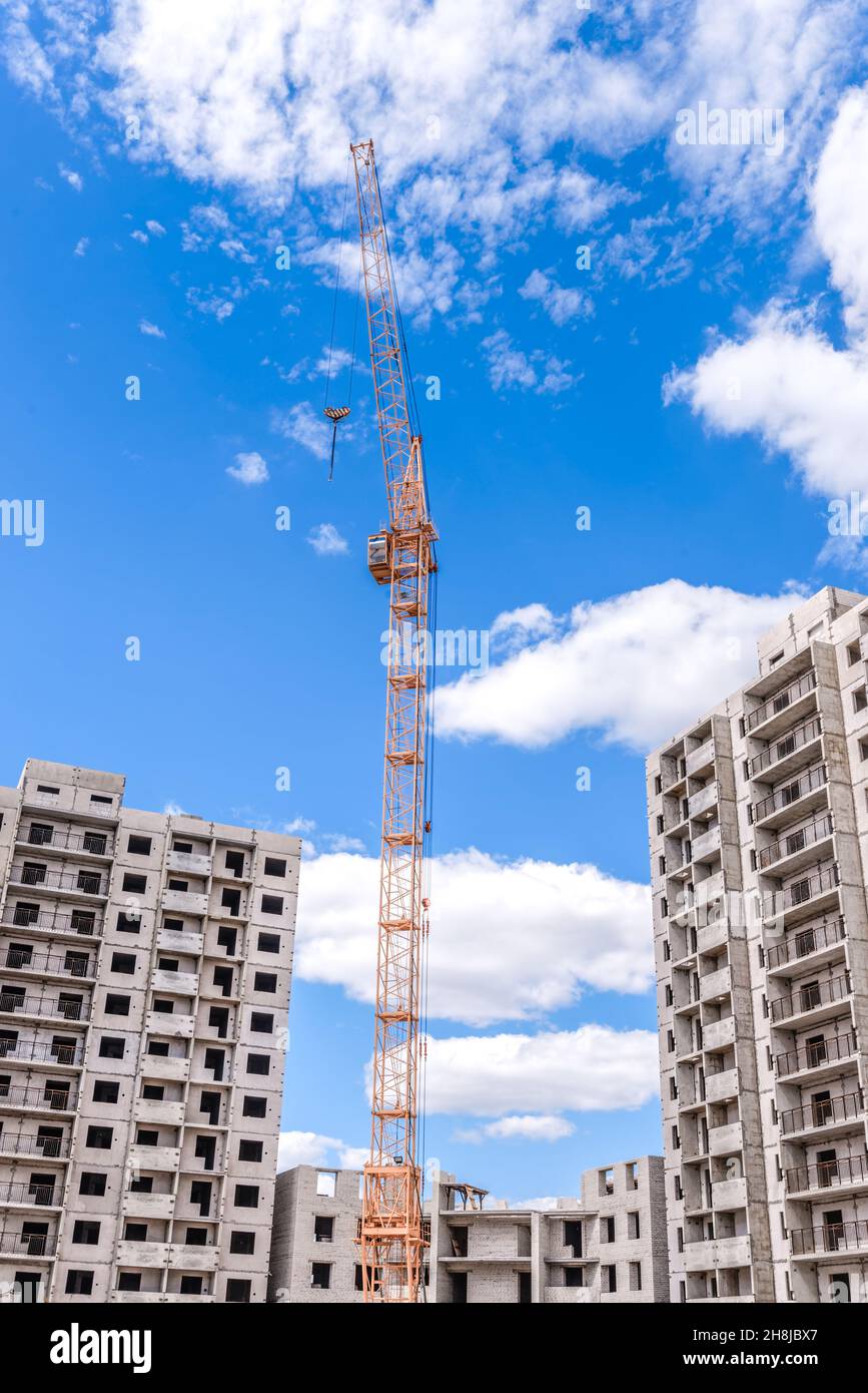 New high-rise building and hoisting crane Stock Photo - Alamy