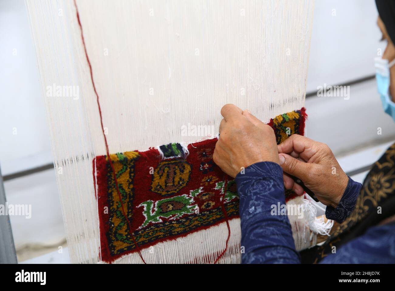 The woman weaving traditional carpet from Gala with colorful wool . The ...