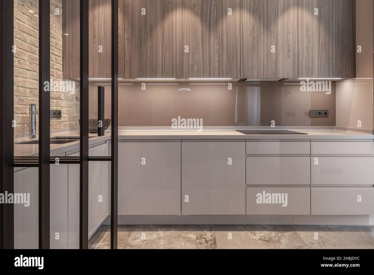 Kitchen contemporary style in beige tones with brick wall and shiny ...